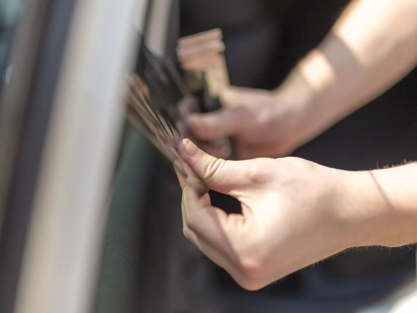 Foto einer Person, die Autoscheibentönung entfernt.