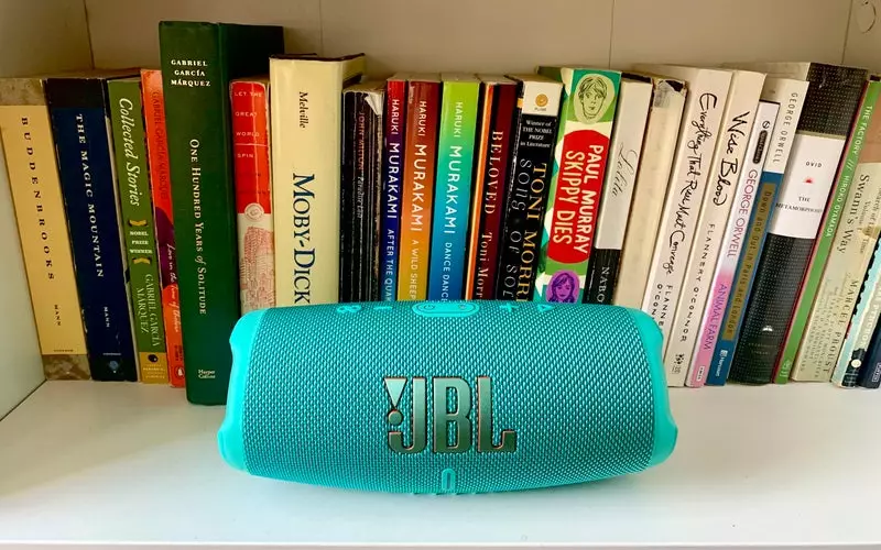 JBL Charge 5 ជាពណ៌ទឹកក្រូចនៅលើធ្នើសៀវភៅ